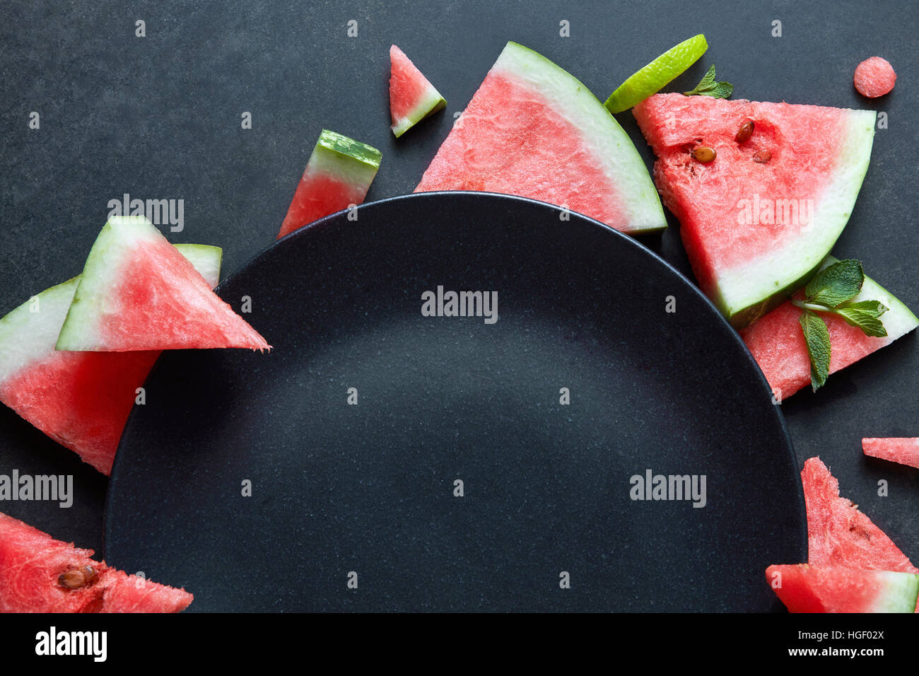 slices of watermelon placed in a circle on black plate Stock Photo - Alamy