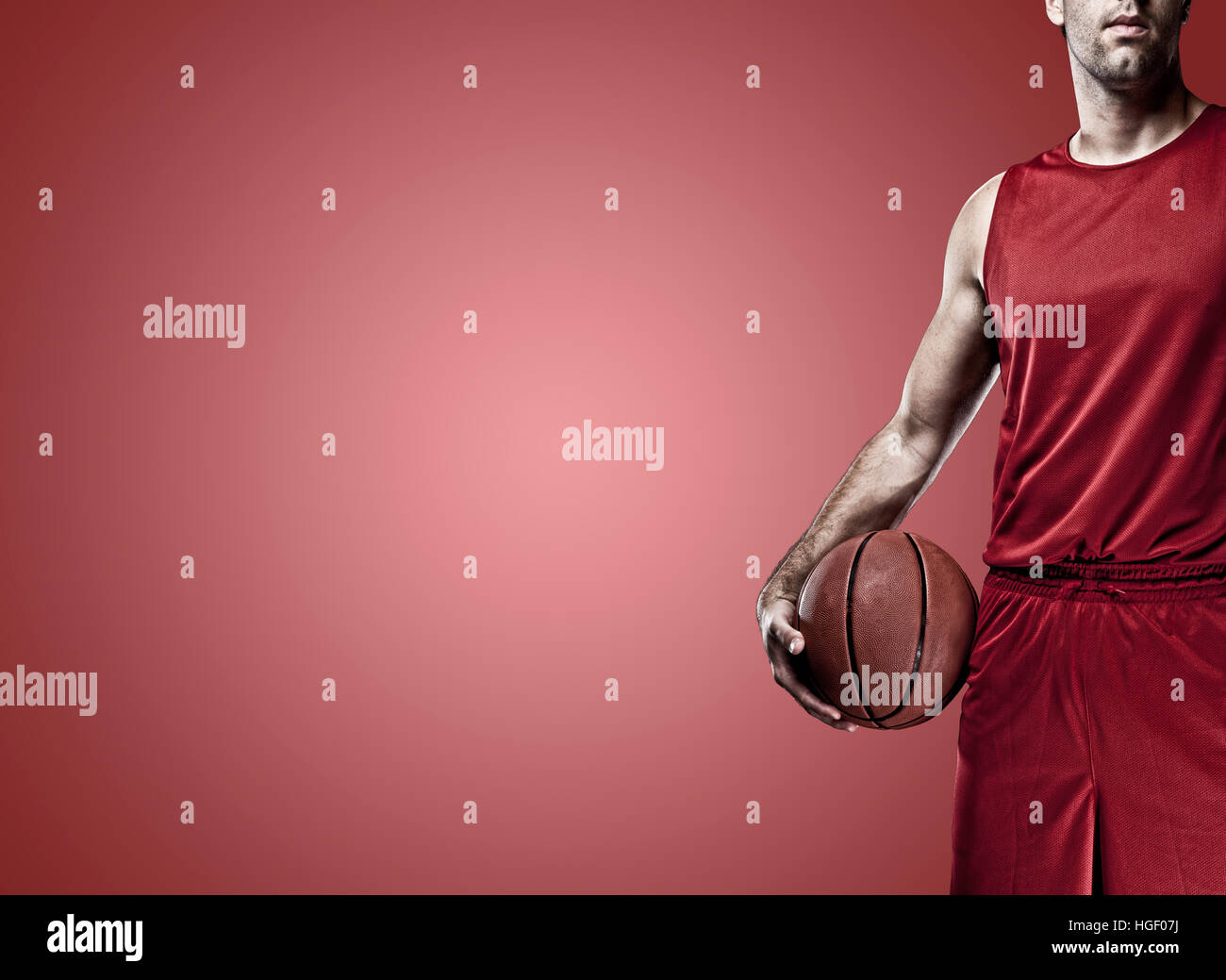Basketball player on a red uniform, on a red backgrond Stock Photo - Alamy
