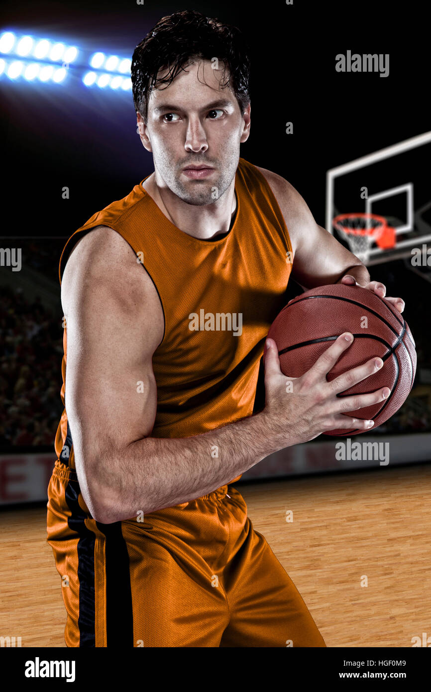 Basketball player on a orange uniform, on a court Stock Photo - Alamy