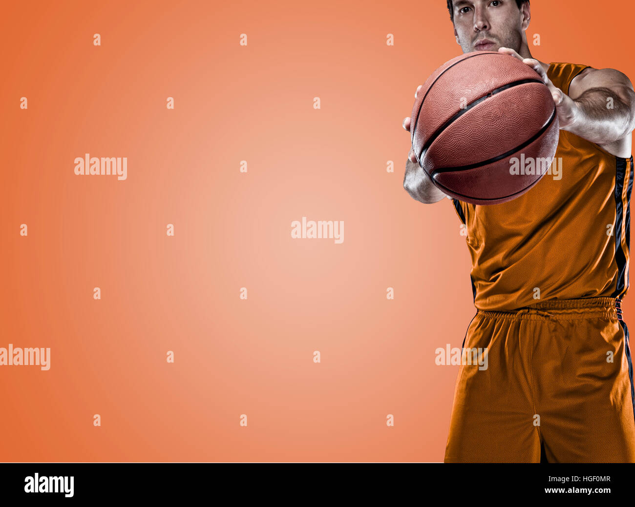 Basketball player on a orange uniform, on a orange background Stock ...