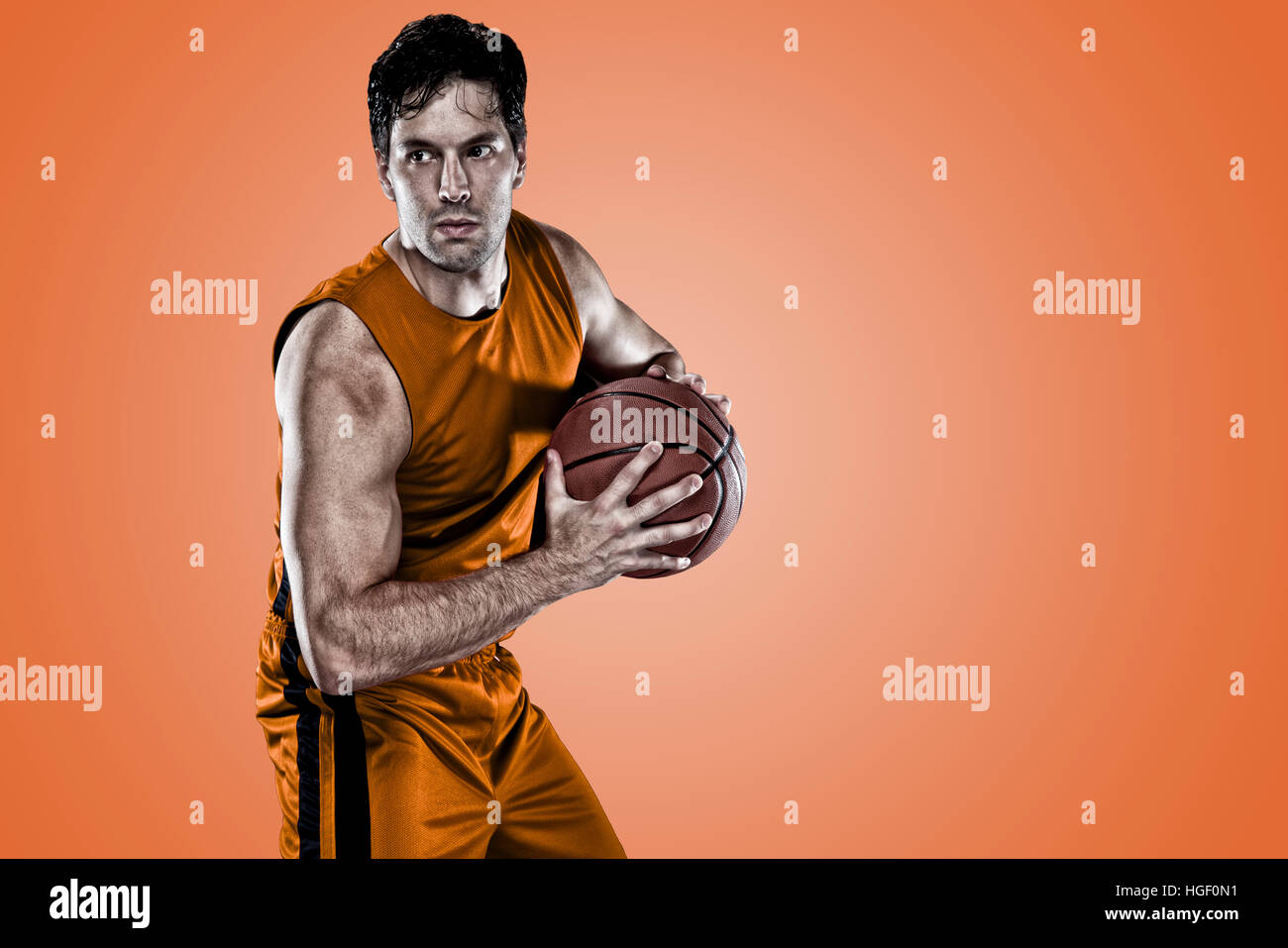 Basketball player on a orange uniform, on a orange background Stock ...
