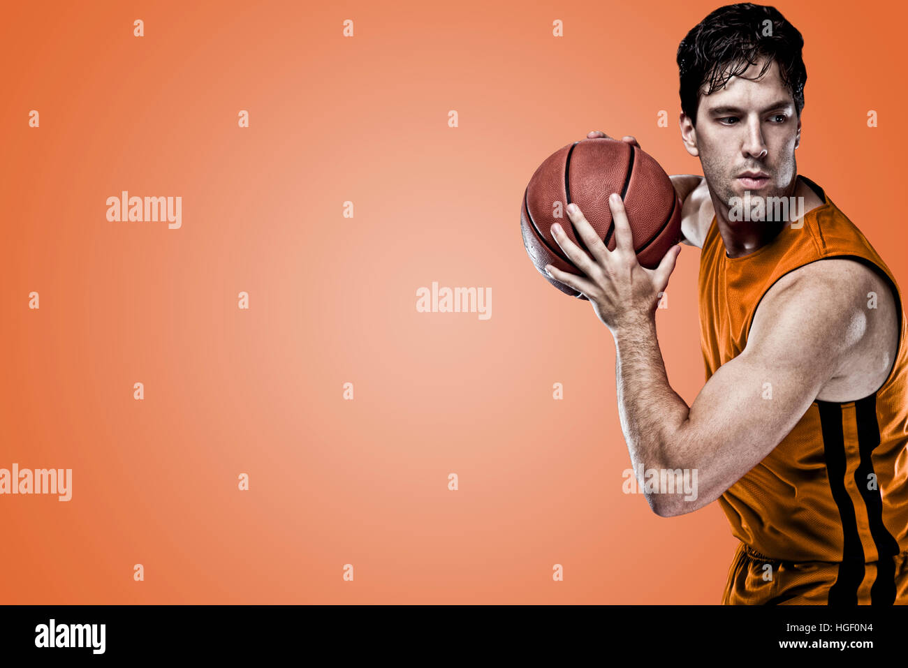 Basketball player on a orange uniform, on a orange background Stock ...