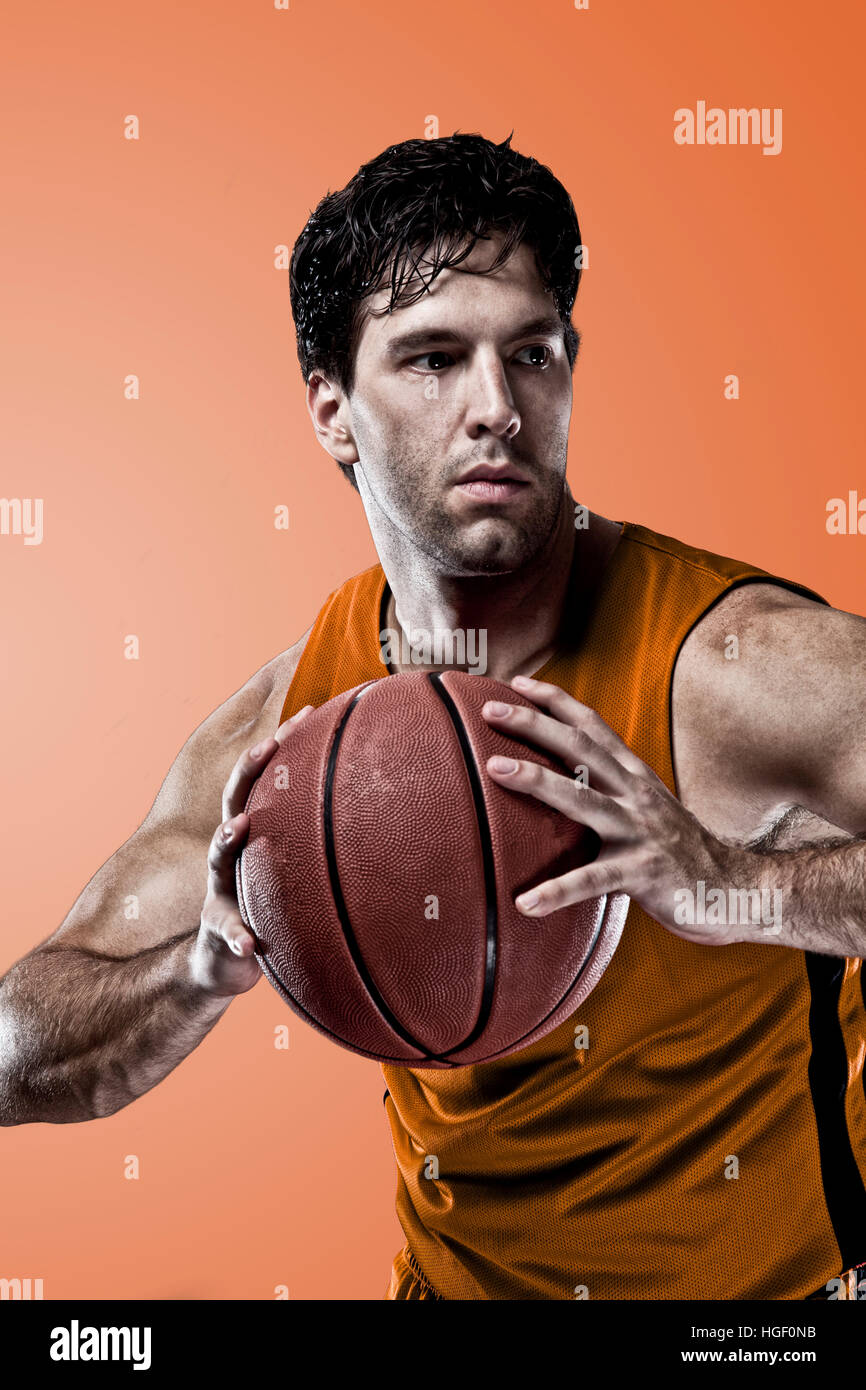 Basketball player on a orange uniform, on a orange background Stock ...