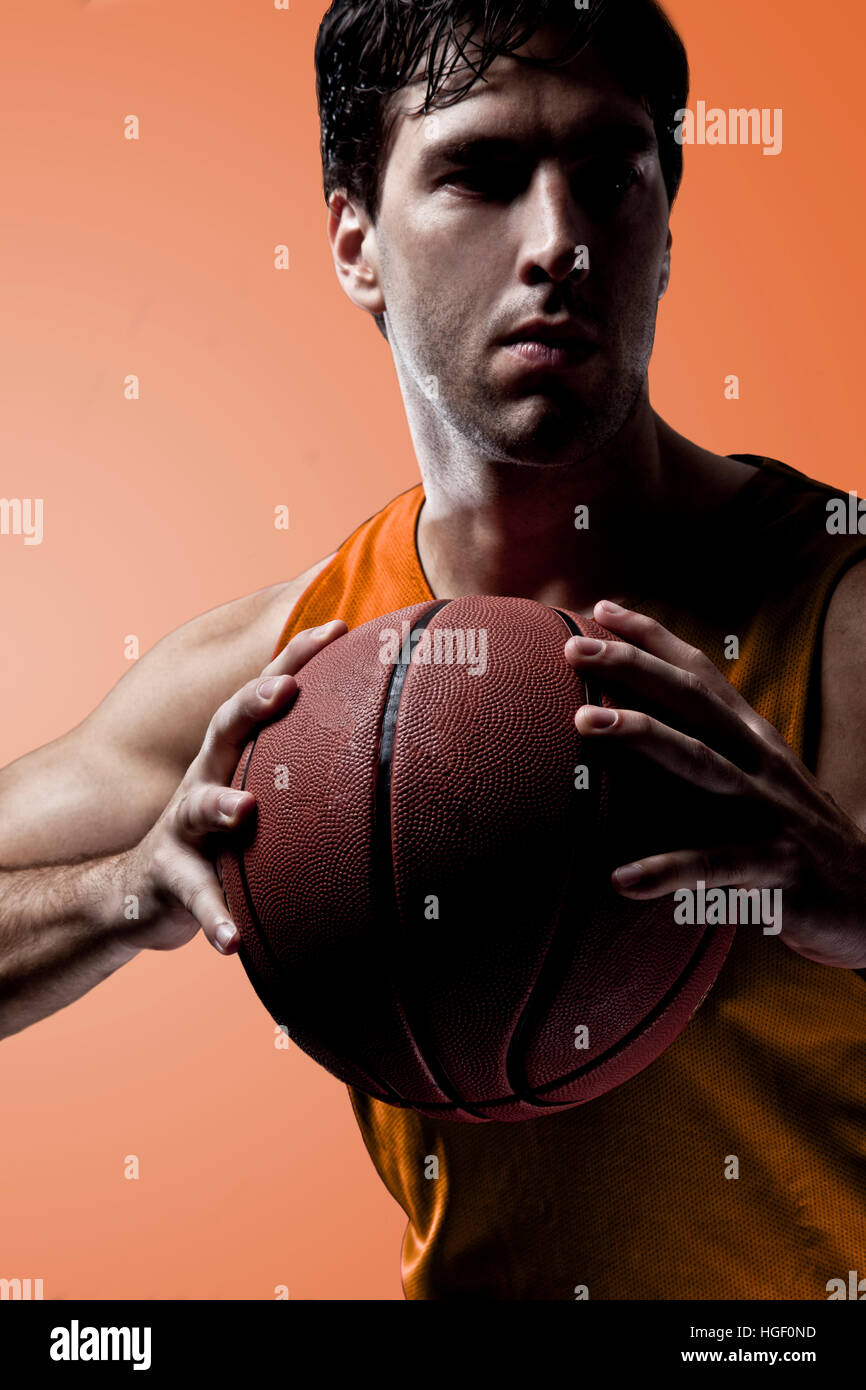 Basketball player on a orange uniform, on a orange background Stock ...
