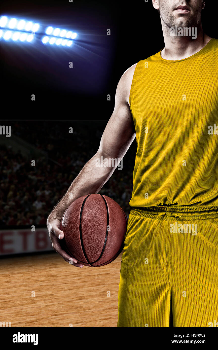 Basketball player on a yellow uniform, on a basketball court Stock ...