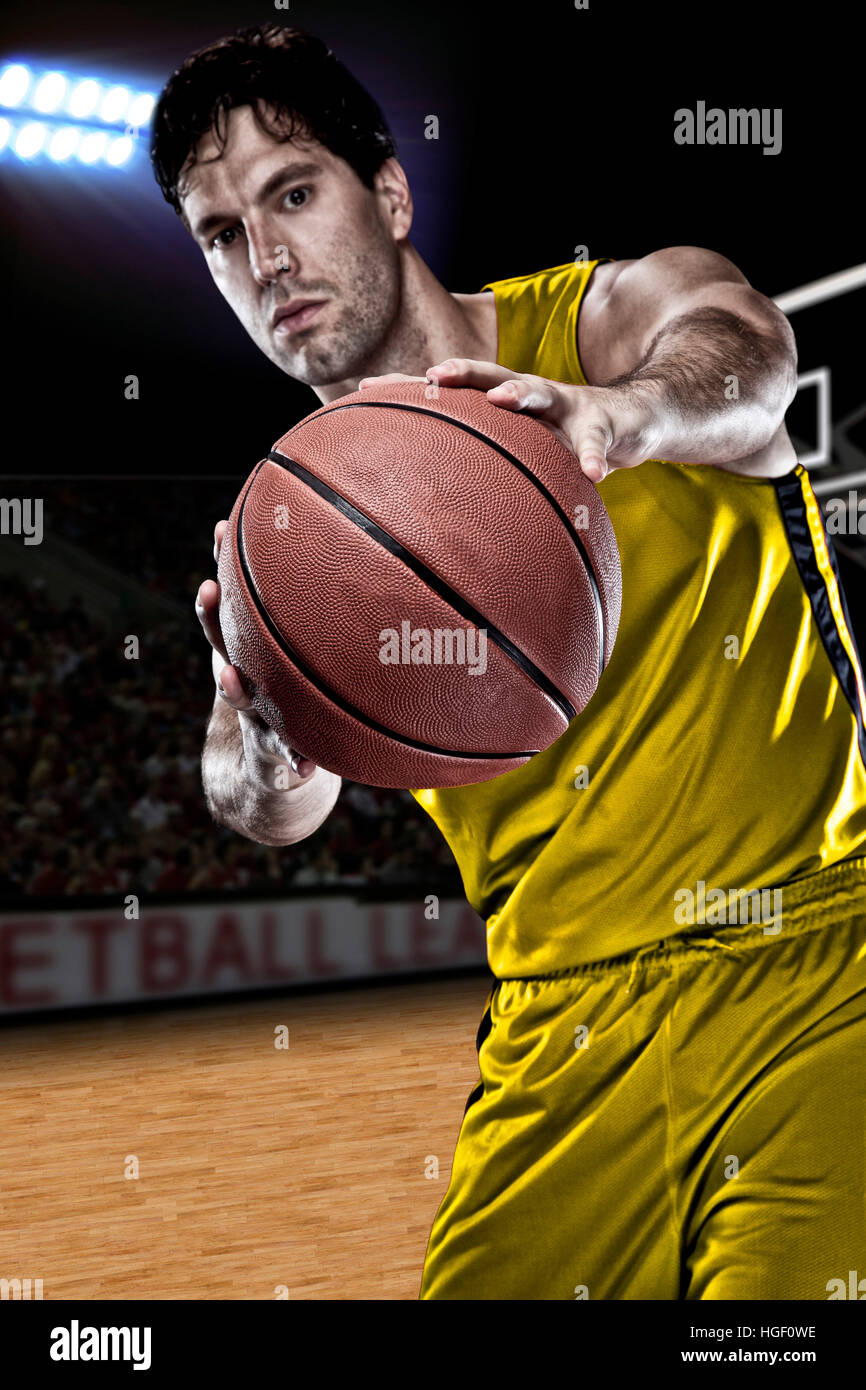 Basketball player on a yellow uniform, on a basketball court Stock ...