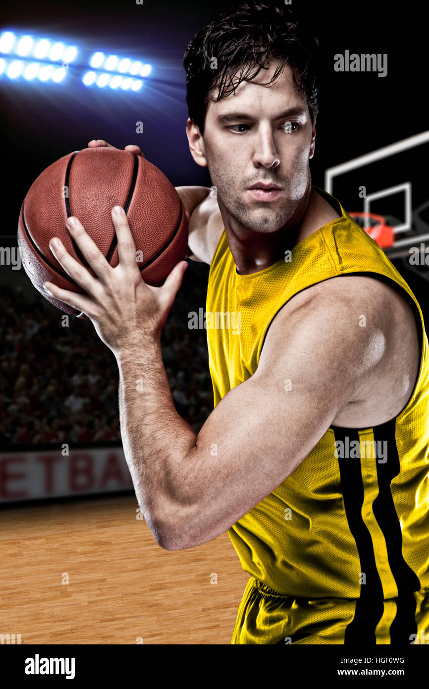 Basketball player on a yellow uniform, on a basketball court Stock ...