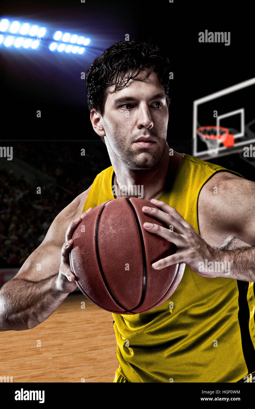 Basketball player on a yellow uniform, on a basketball court Stock ...