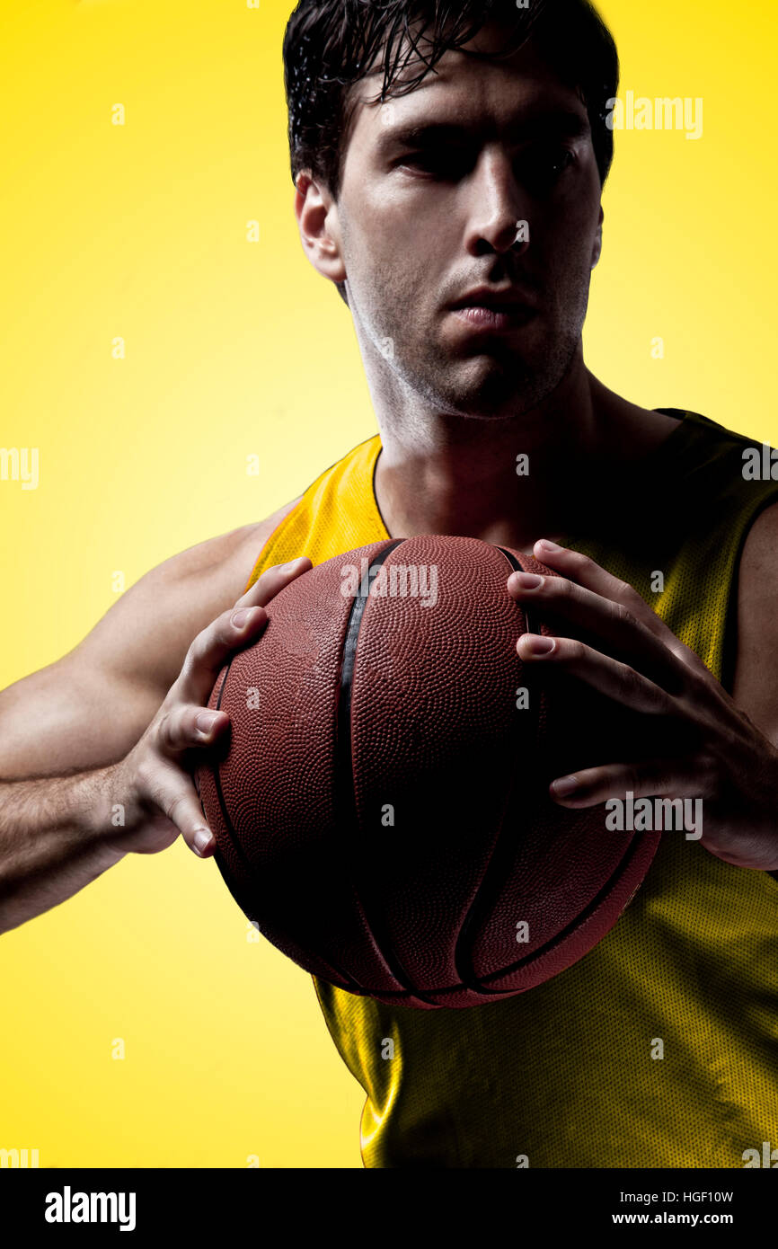 Basketball player on a yellow uniform, on a yellow background Stock ...