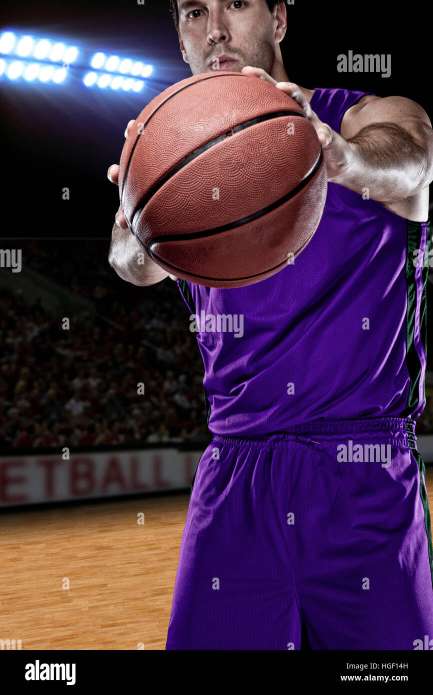 Basketball player on a purple uniform, on a basketball court Stock ...
