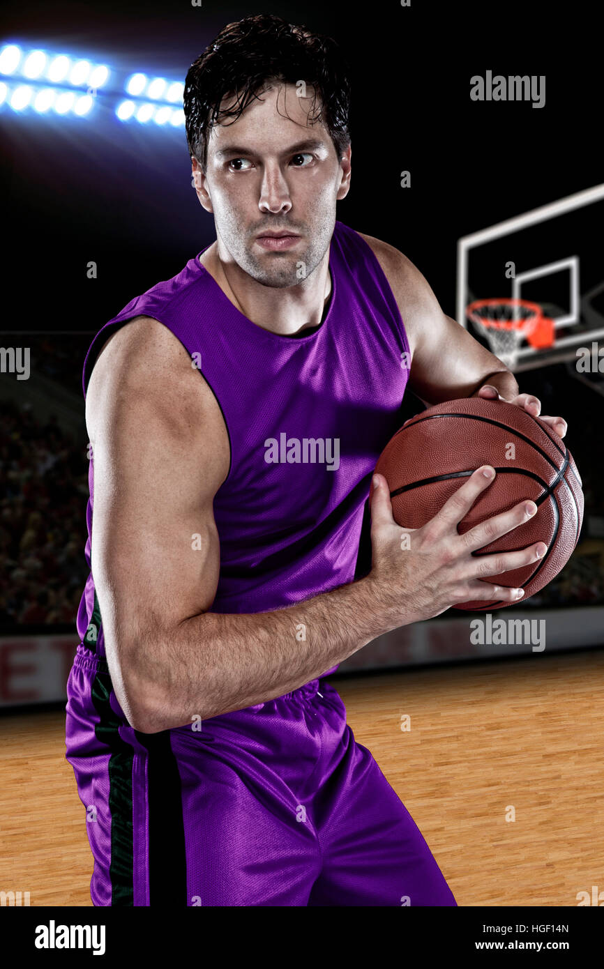 Basketball player on a purple uniform, on a basketball court Stock ...