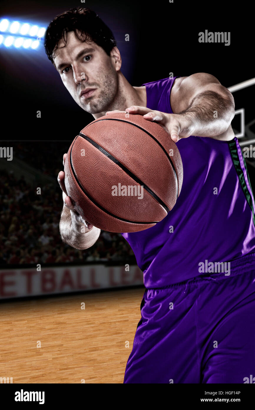 Basketball player on a purple uniform, on a basketball court Stock ...