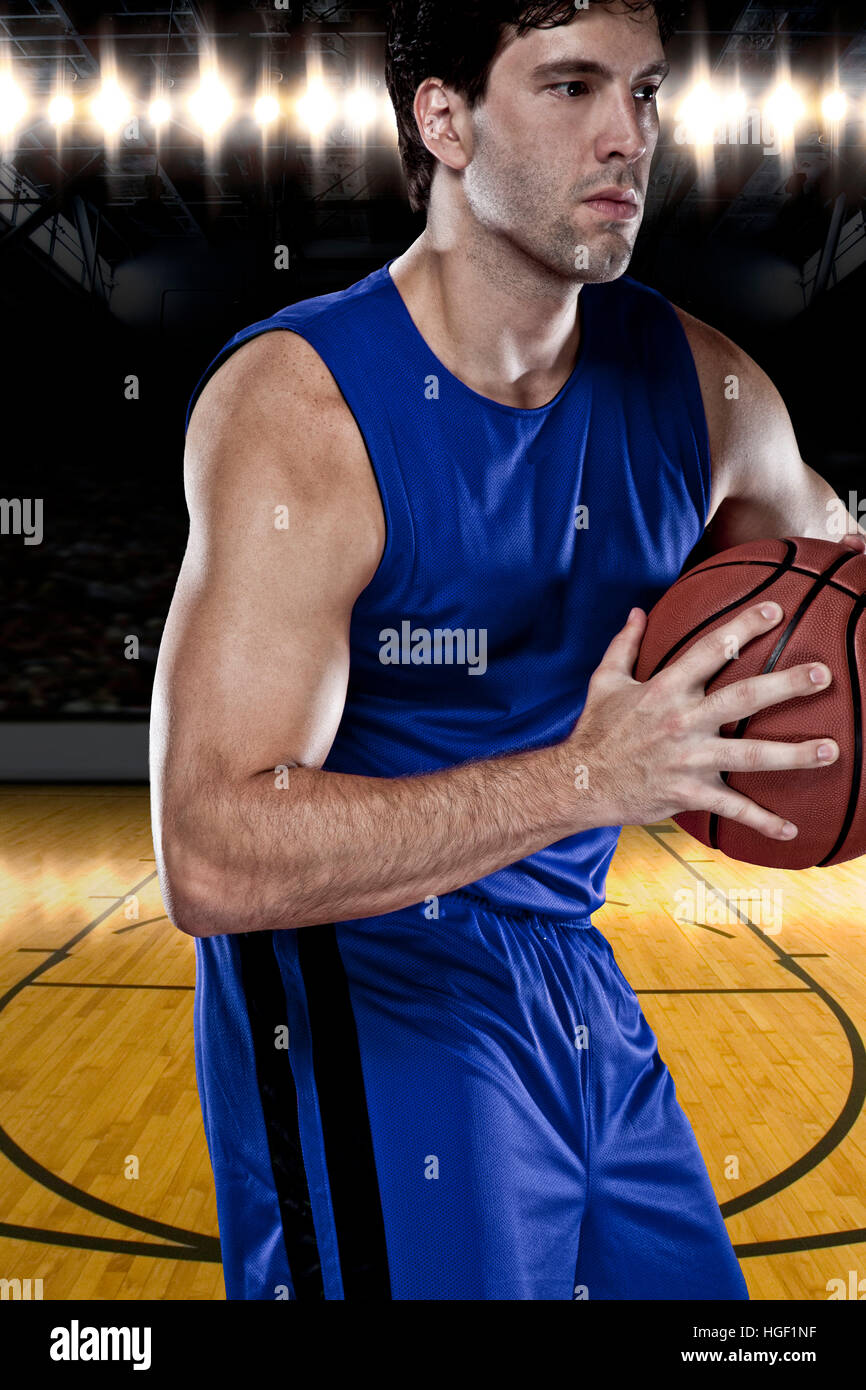 Basketball player on a blue uniform, on a basketball court Stock Photo ...