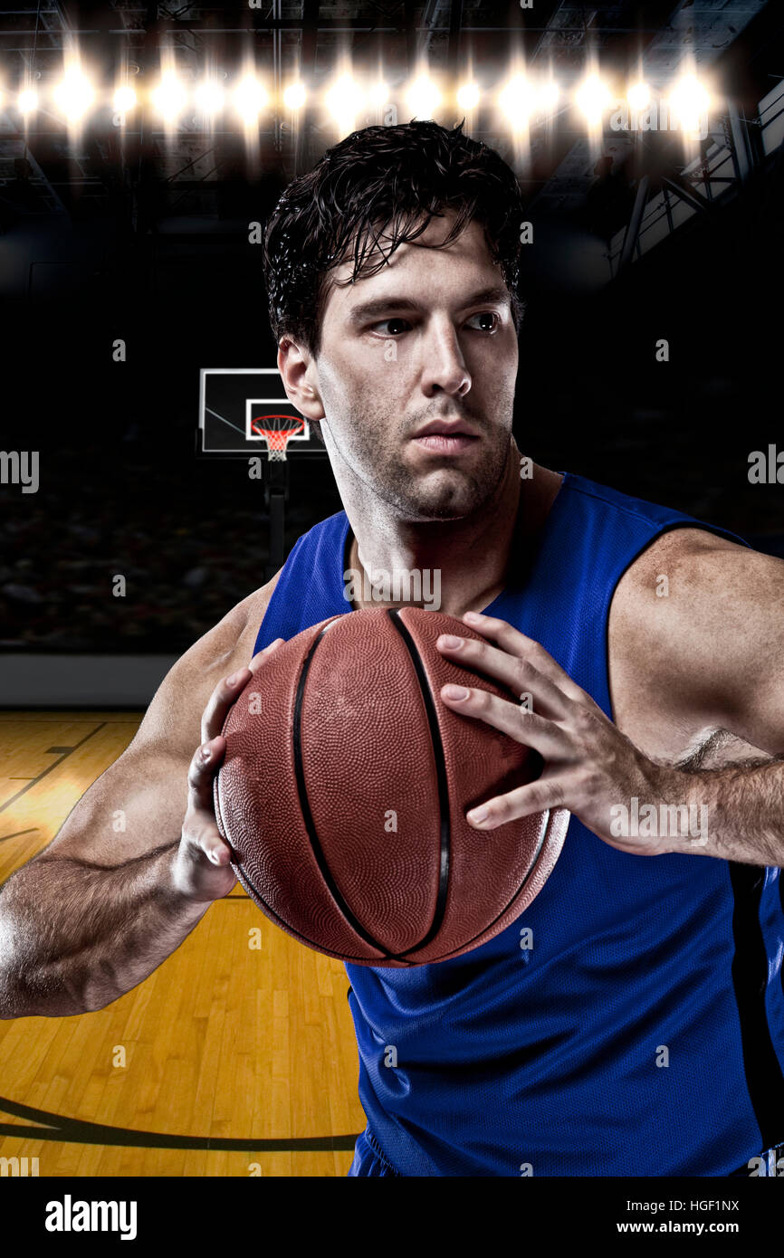 Basketball player on a blue uniform, on a basketball court Stock Photo ...