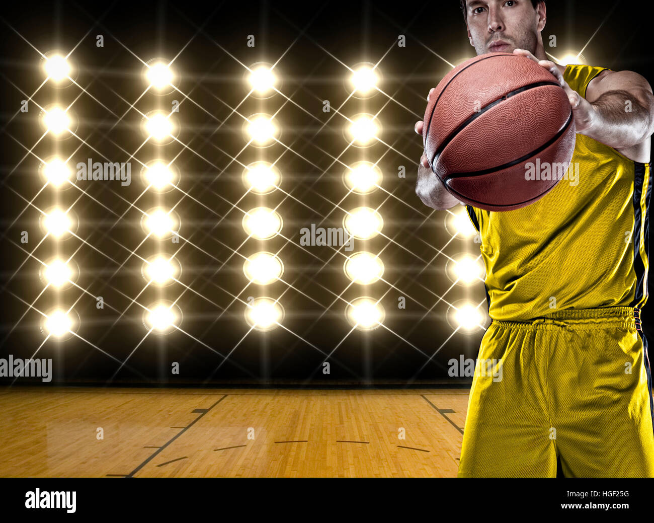 Basketball player on a yellow uniform, in front of lights Stock Photo ...