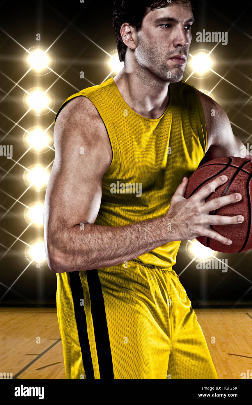 Basketball player on a yellow uniform, in front of lights Stock Photo ...