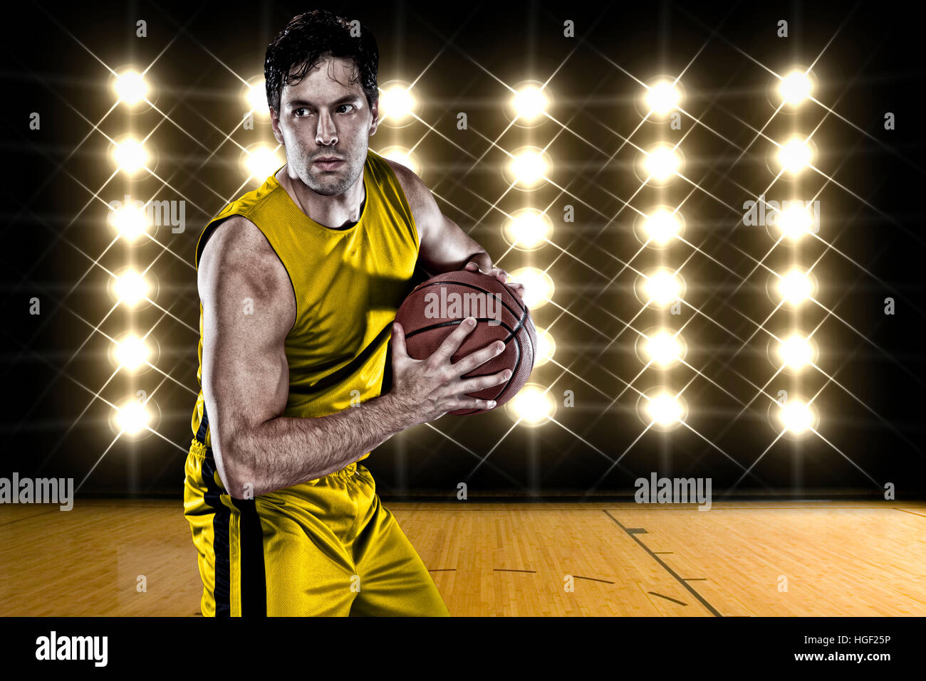 Basketball player on a yellow uniform, in front of lights Stock Photo ...