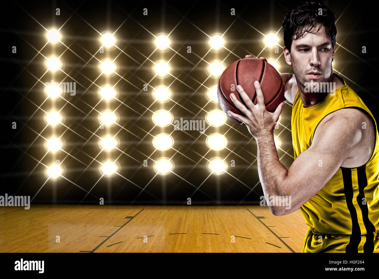 Basketball player on a yellow uniform, in front of lights Stock Photo ...