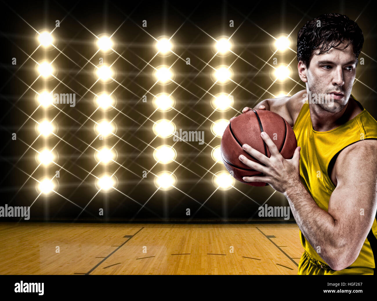 Basketball player on a yellow uniform, in front of lights Stock Photo ...