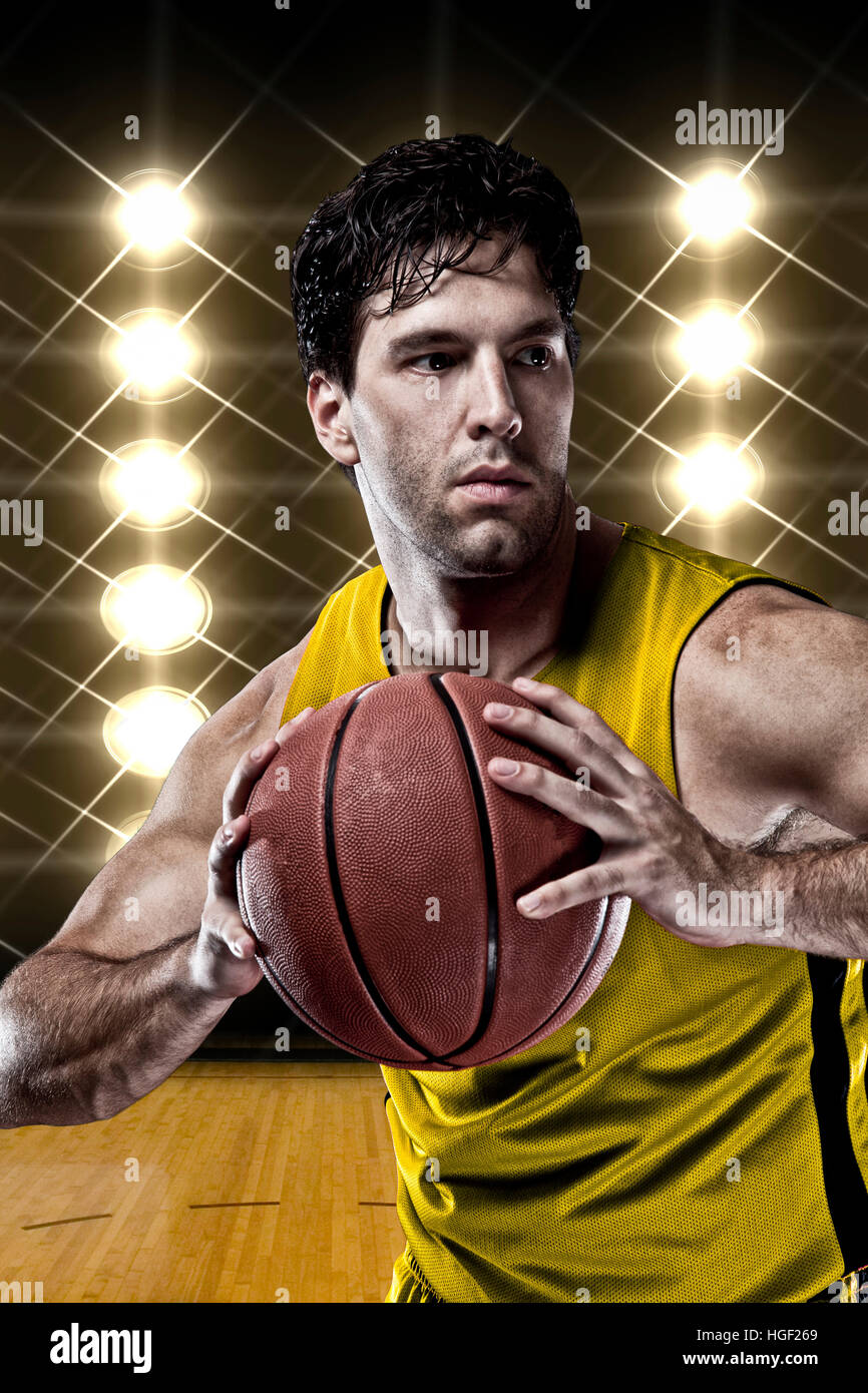 Basketball player on a yellow uniform, in front of lights Stock Photo ...