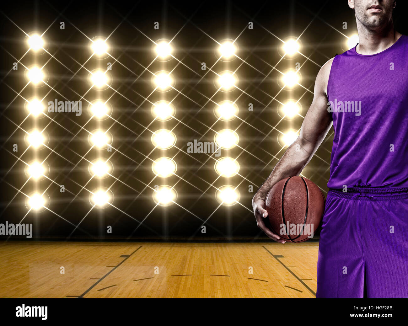 Basketball player on a purple uniform, in front of lights Stock Photo ...