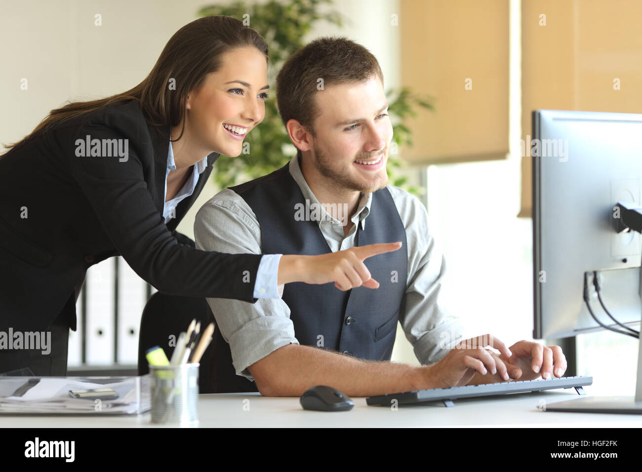 Coworkers working on line with a desktop computer in a desktop at ...