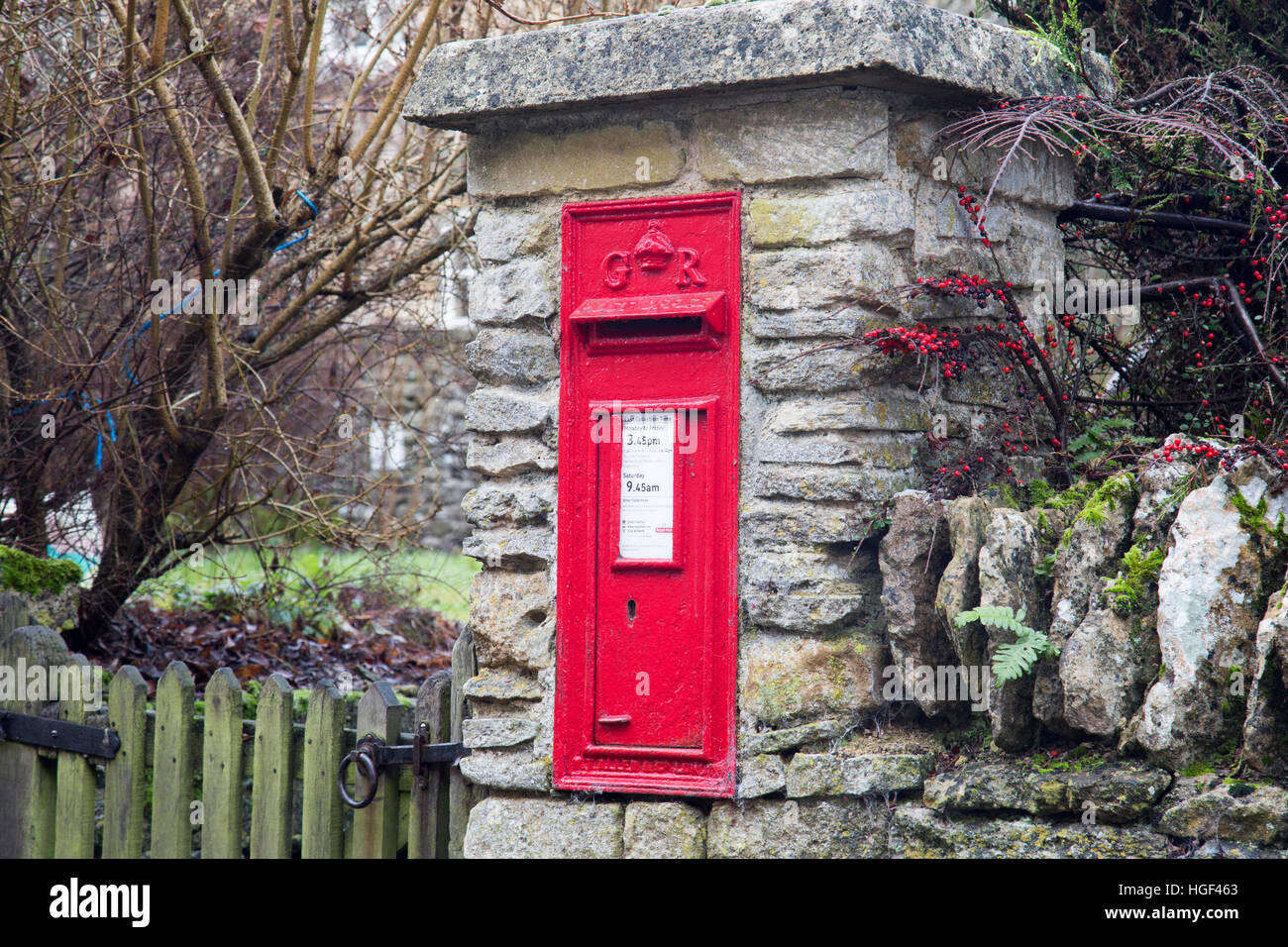 traditional red letter box set in stone wall in the Cotswolds village ...
