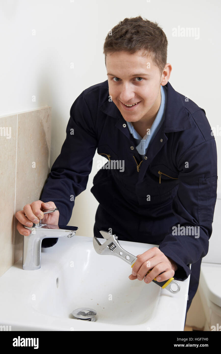 Male Plumber Working On Sink Using Wrench Stock Photo - Alamy