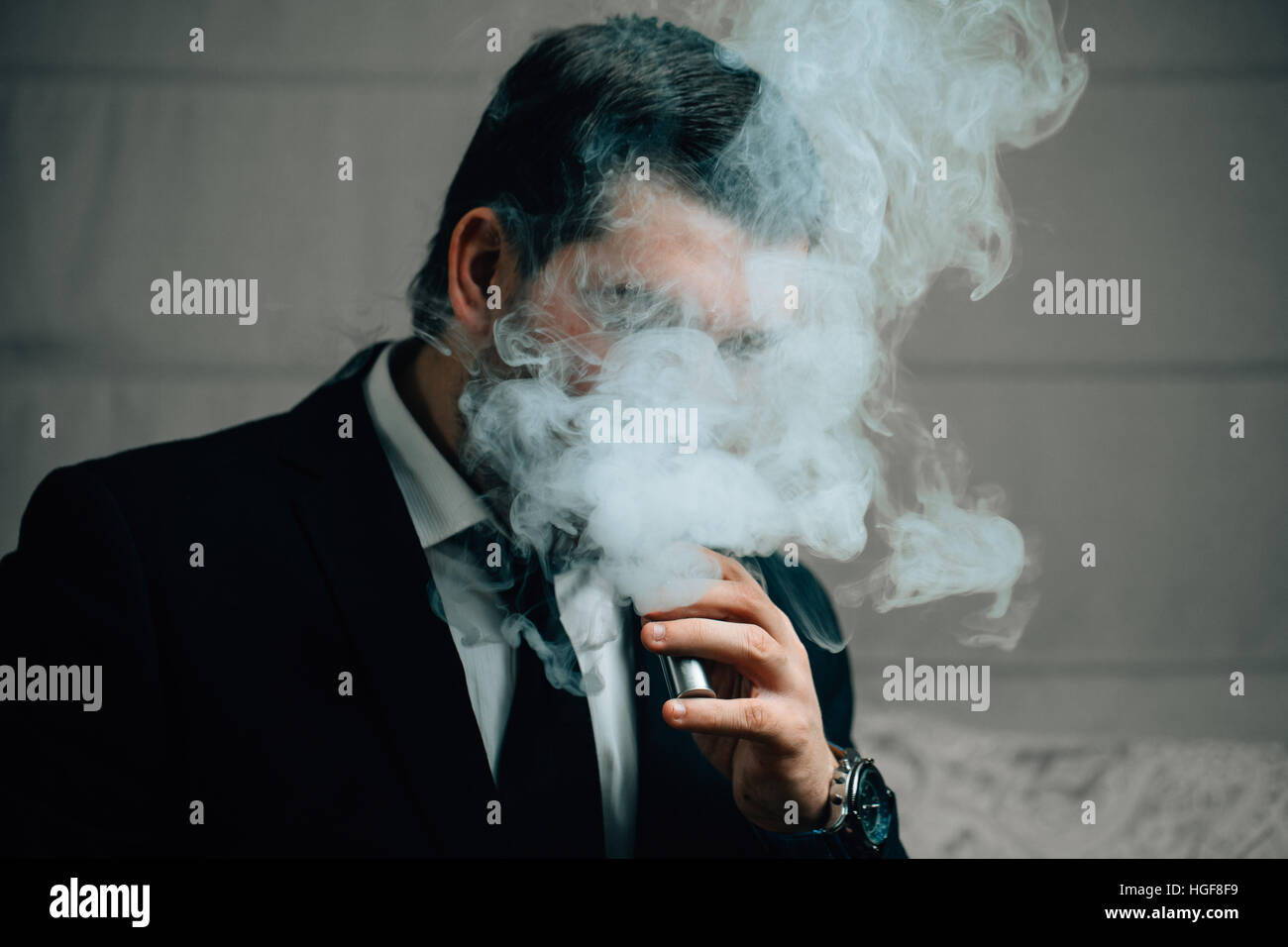 businessman smoking electronic cigarette Stock Photo - Alamy