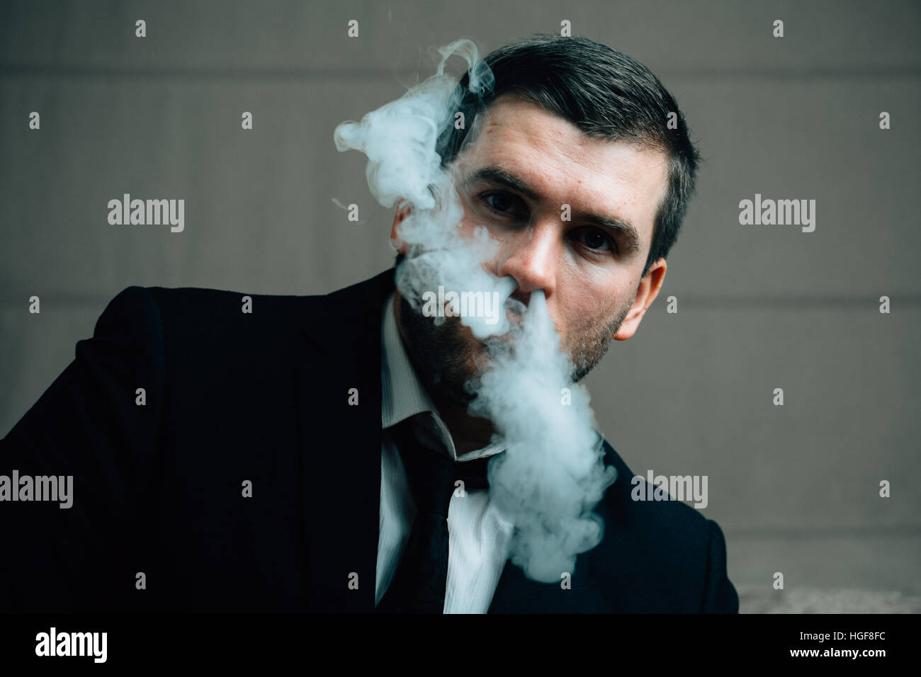 businessman blows smoke from his nose Stock Photo - Alamy