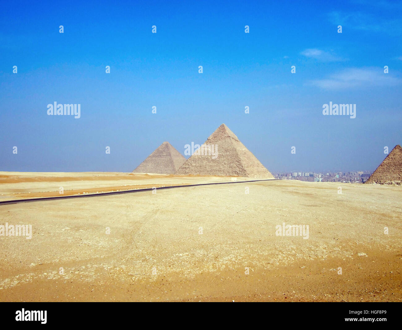 road to pyramids Giza in background of blue sky and Cairo, Egypt Stock ...