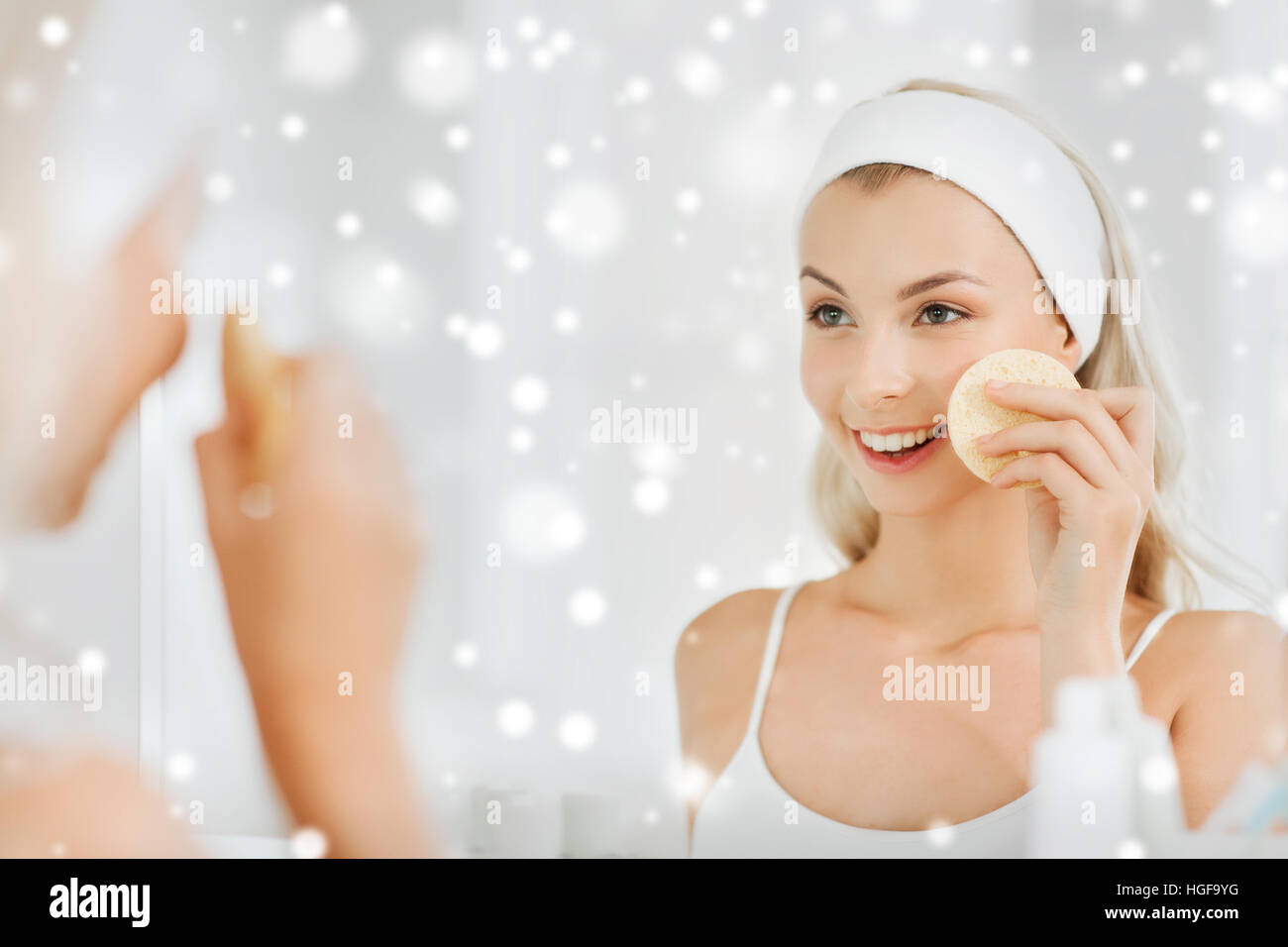 young woman washing face with sponge at bathroom Stock Photo - Alamy