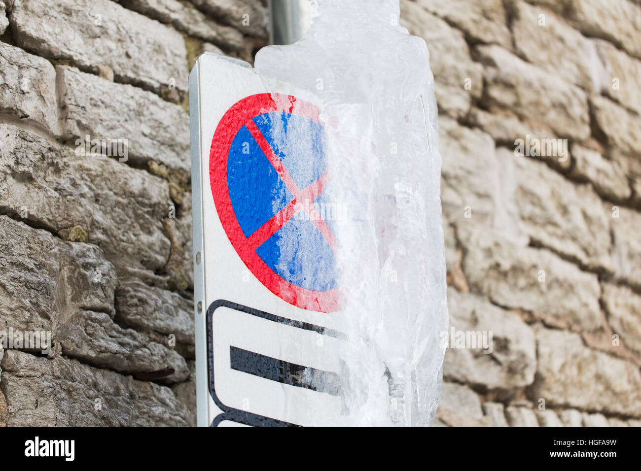 ice-covered no stopping road sign over wall Stock Photo - Alamy