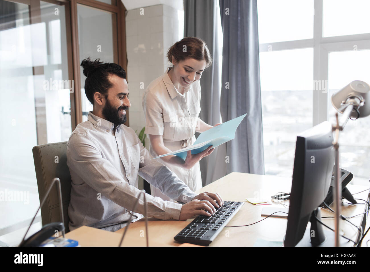 happy creative team with computer in office Stock Photo - Alamy