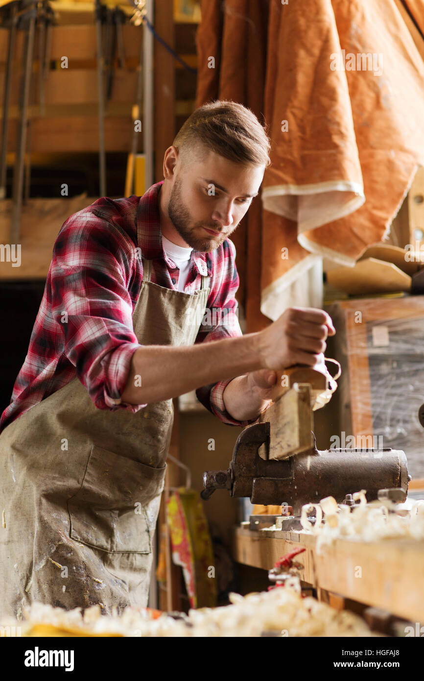 carpenter working with plane and wood at workshop Stock Photo - Alamy