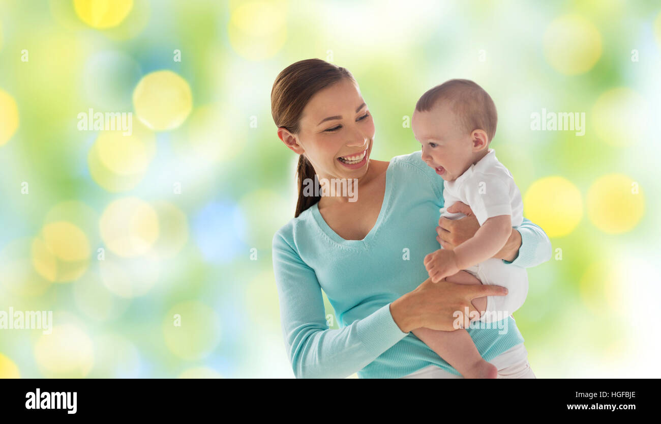 happy mother with little baby over green lights Stock Photo - Alamy