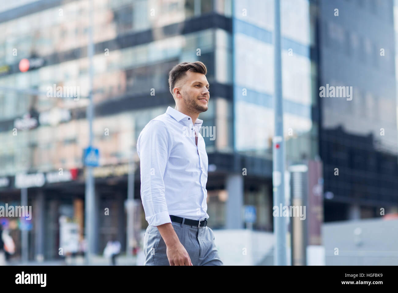 young man walking along city street Stock Photo - Alamy