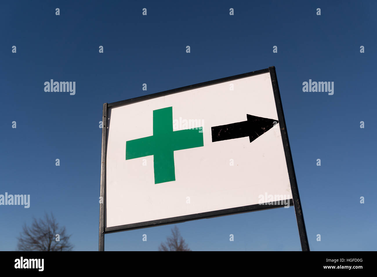 A sign with a green cross shows the location of a marijuana dispensary ...