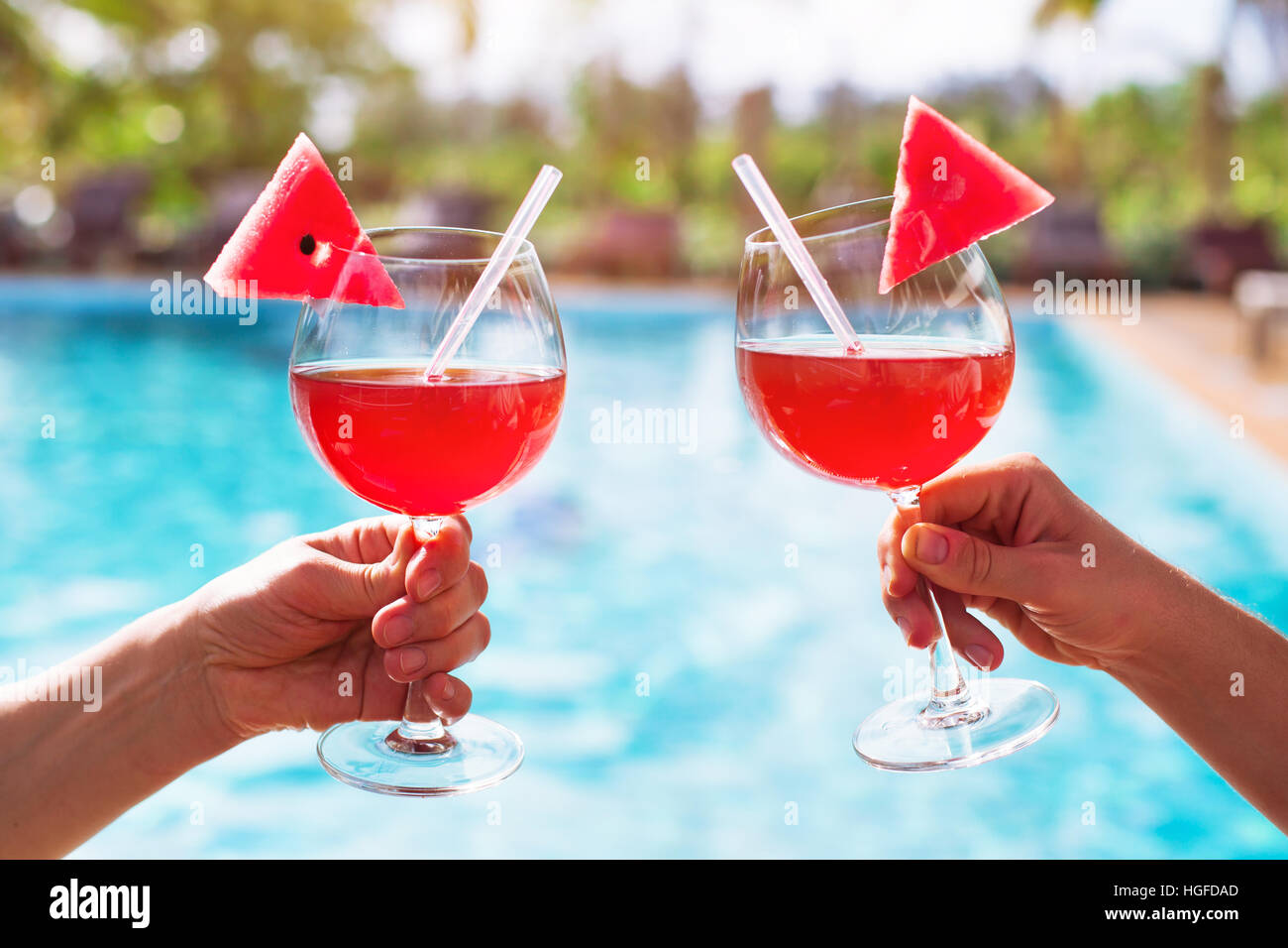 couple drinking cocktails near luxurious swimming pool in hotel ...