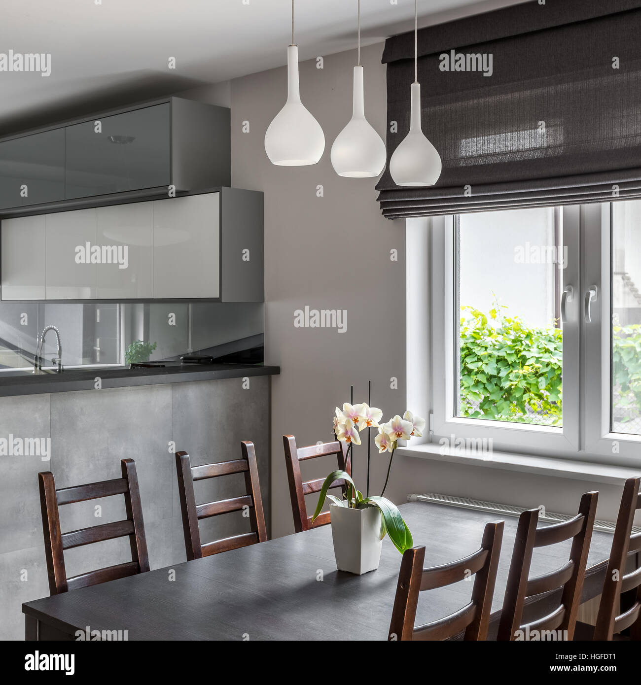 Dining area with table, wooden chairs and decorative window roller ...