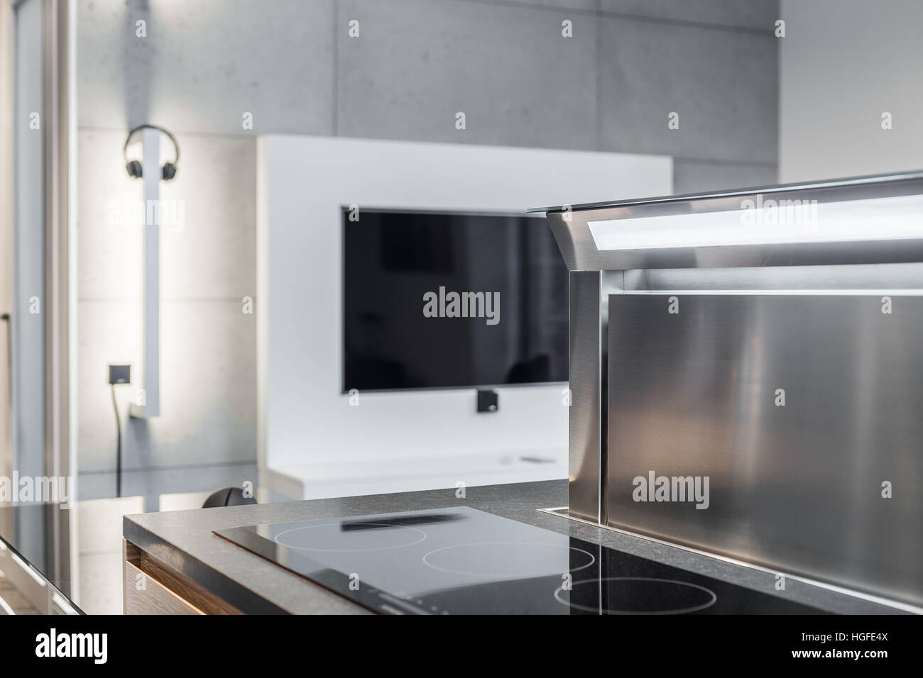 Stylish interior with induction hob, modern tv and grey wall tiles ...