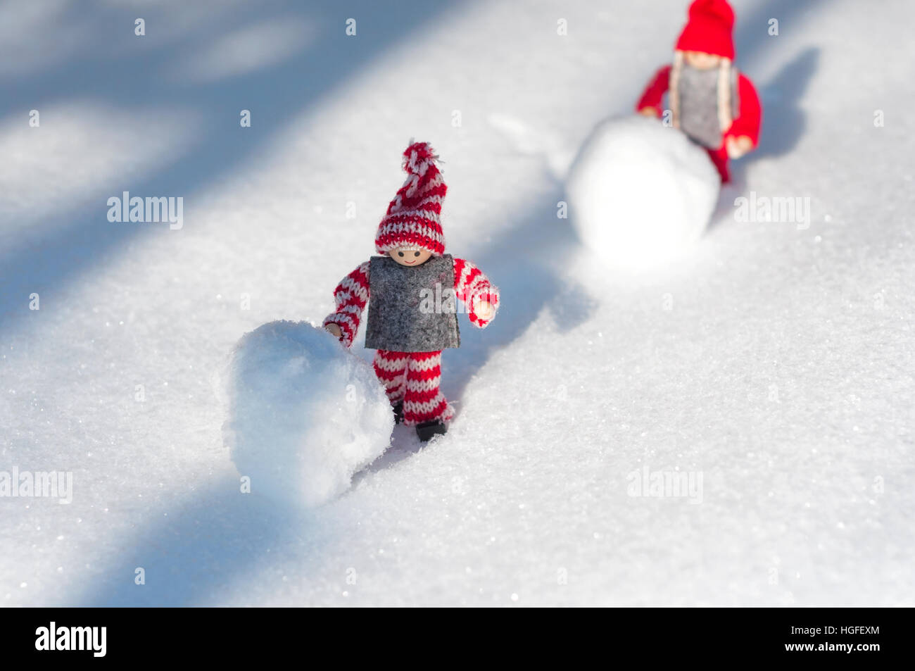 Two small toys in a scene in the snow, pushing snow balls Stock Photo ...