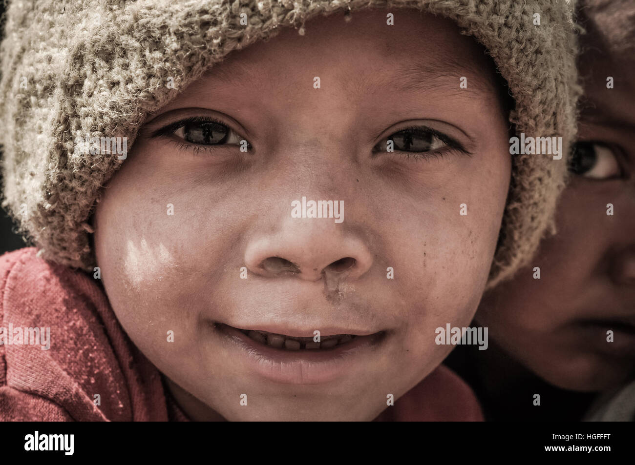 Beni, Nepal - circa May 2012: Young boy with brown eyes and brown cap ...