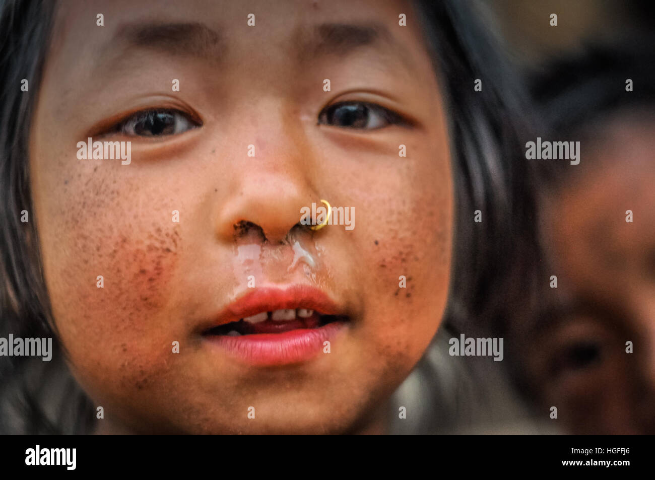 Dolpo, Nepal - circa May 2012: Small brown-eyed girl with piercing in ...