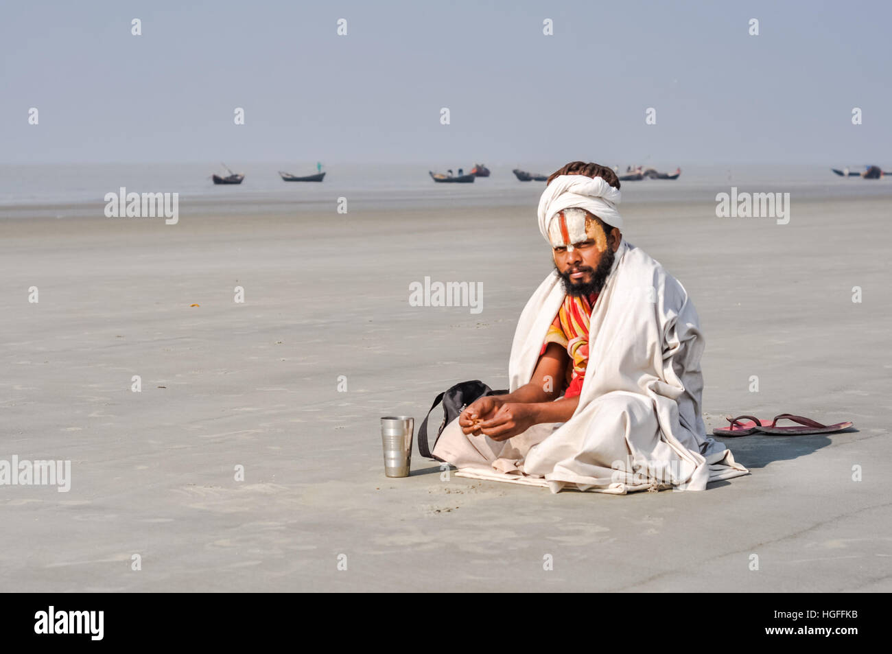 Ganga Sagar, West Bengal - circa January 2012: Native man in white coat ...