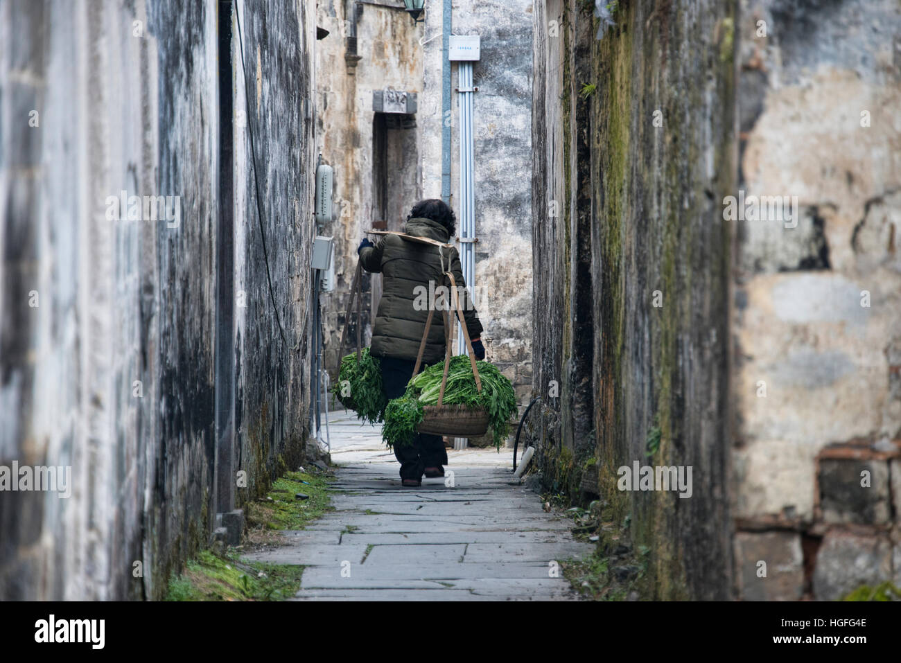 Carrying vegetables in the ancient village of Xidi, Anhui, China Stock ...