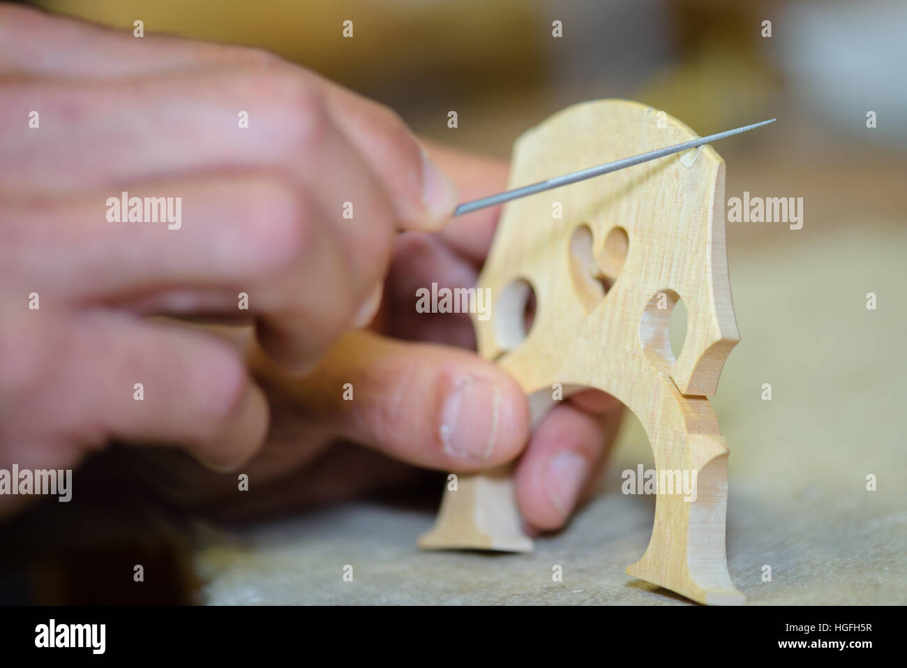 Closeup of craftsman making musical instrument bridge Stock Photo - Alamy