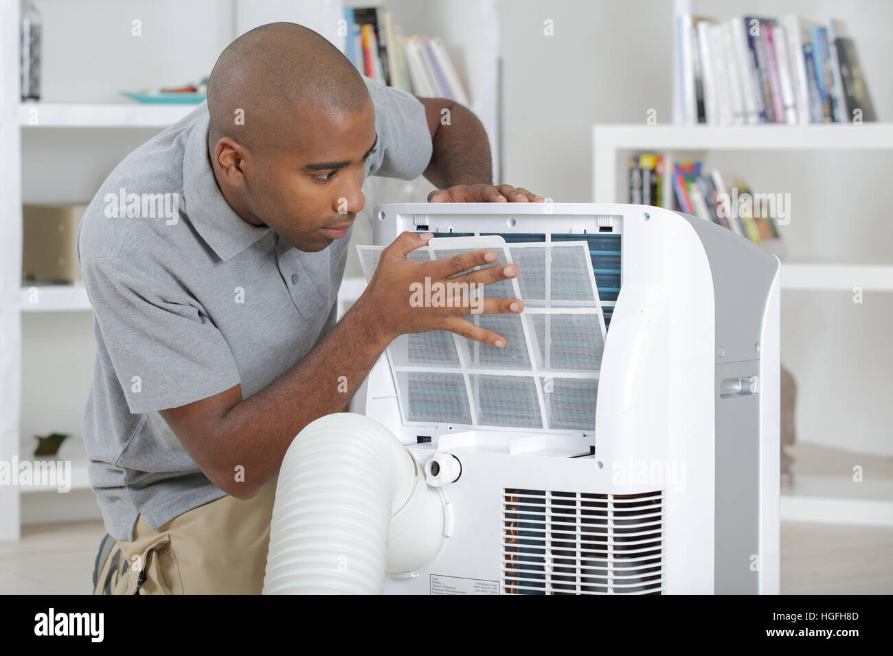 young male technician cleaning air conditioning system at home Stock ...