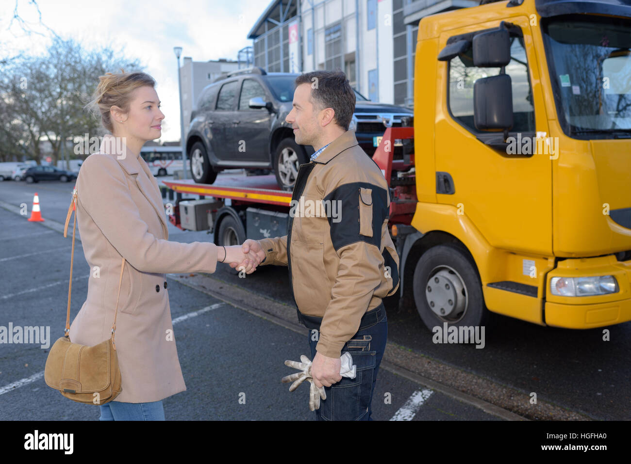 Vehicle assistance worker shaking hands with customer Stock Photo - Alamy