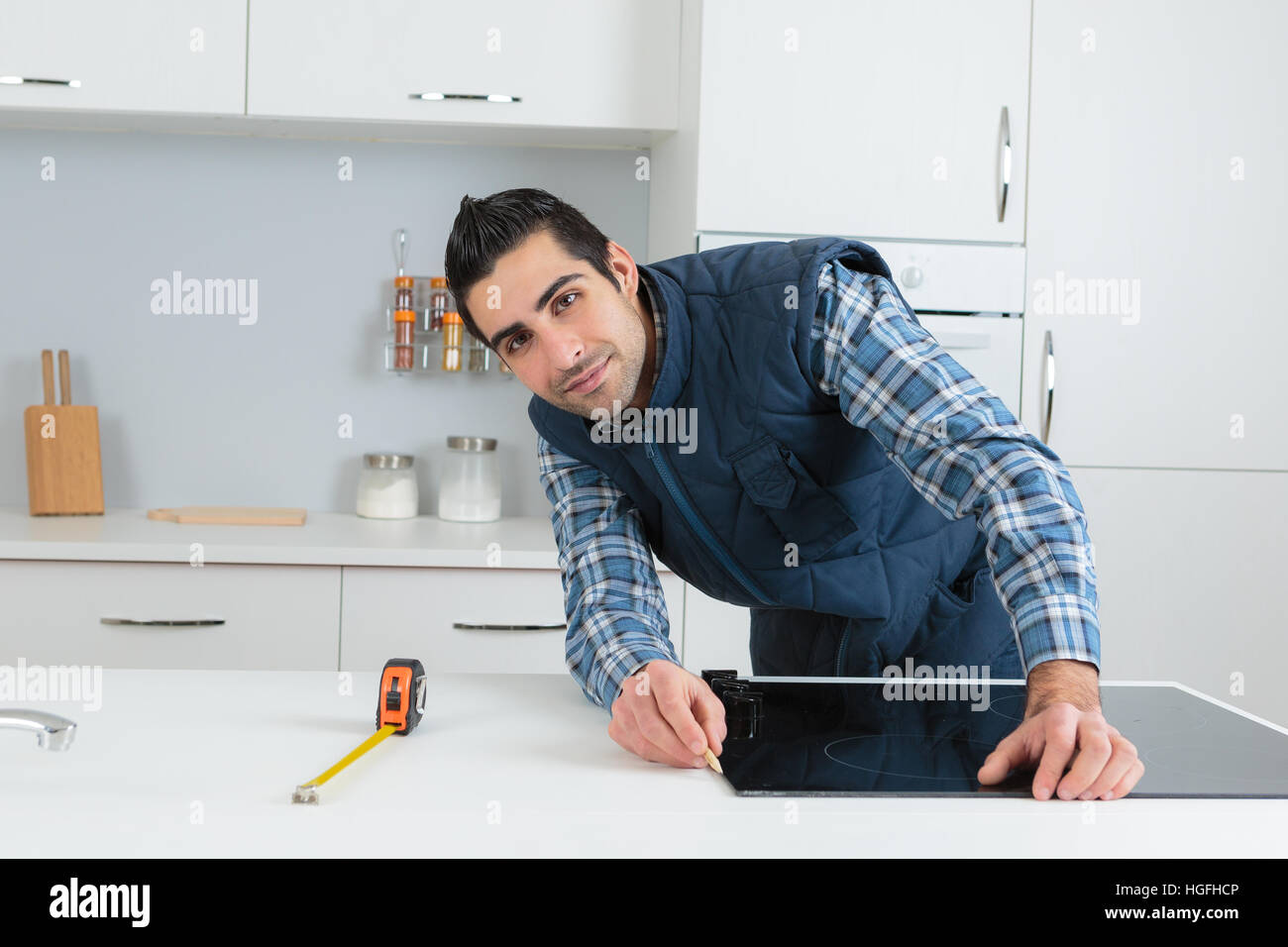 builder installing induction hot plate Stock Photo - Alamy
